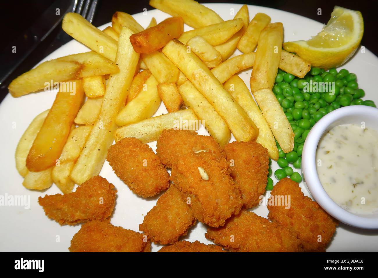 A tasty view of Crispy Cod Bites along with chips and Peas Stock Photo ...