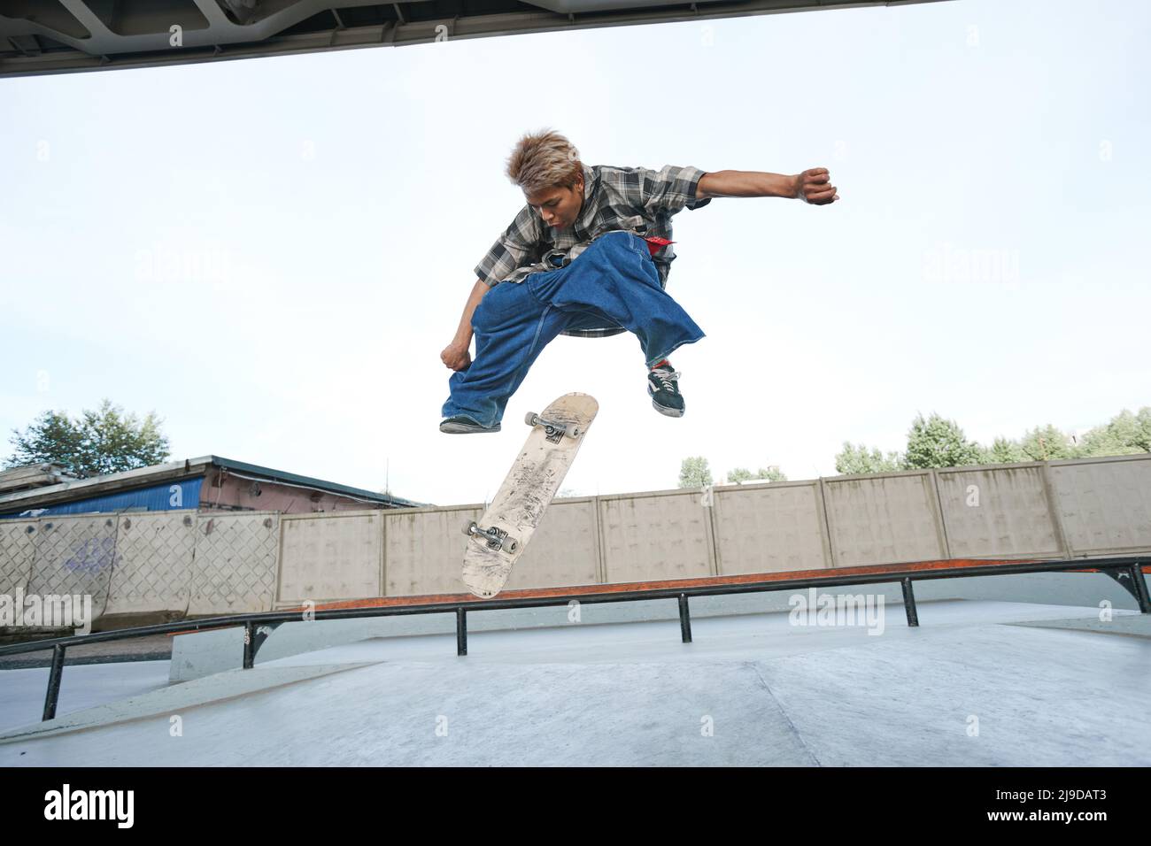 Portrait of teenage boy doing skateboard tricks in air at outdoor ...
