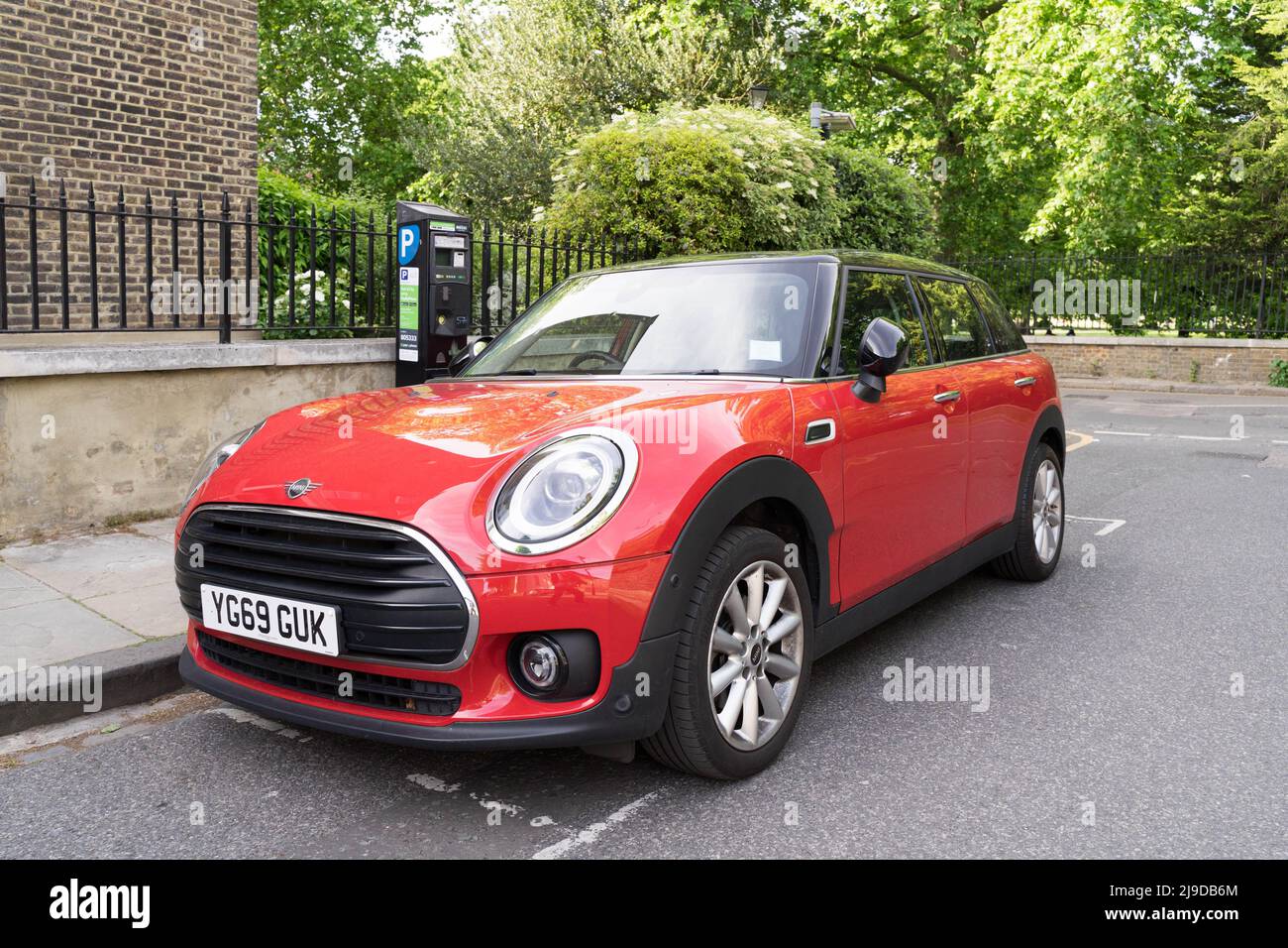 side view of Red MINI parks in on street parking bay next to parking ...