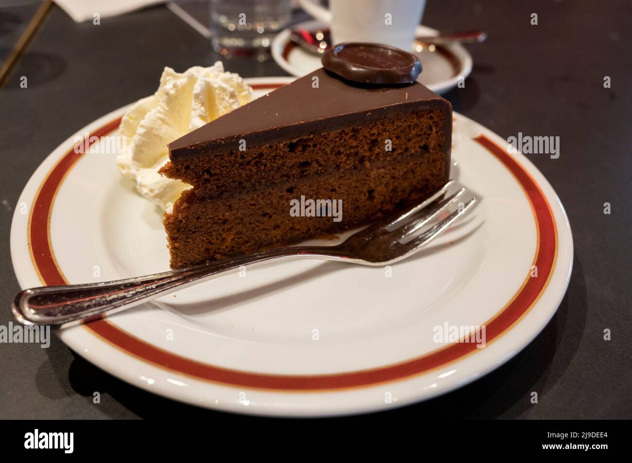 Piece of famous Sachertorte chocolate cake with apricot jam of Austrian ...