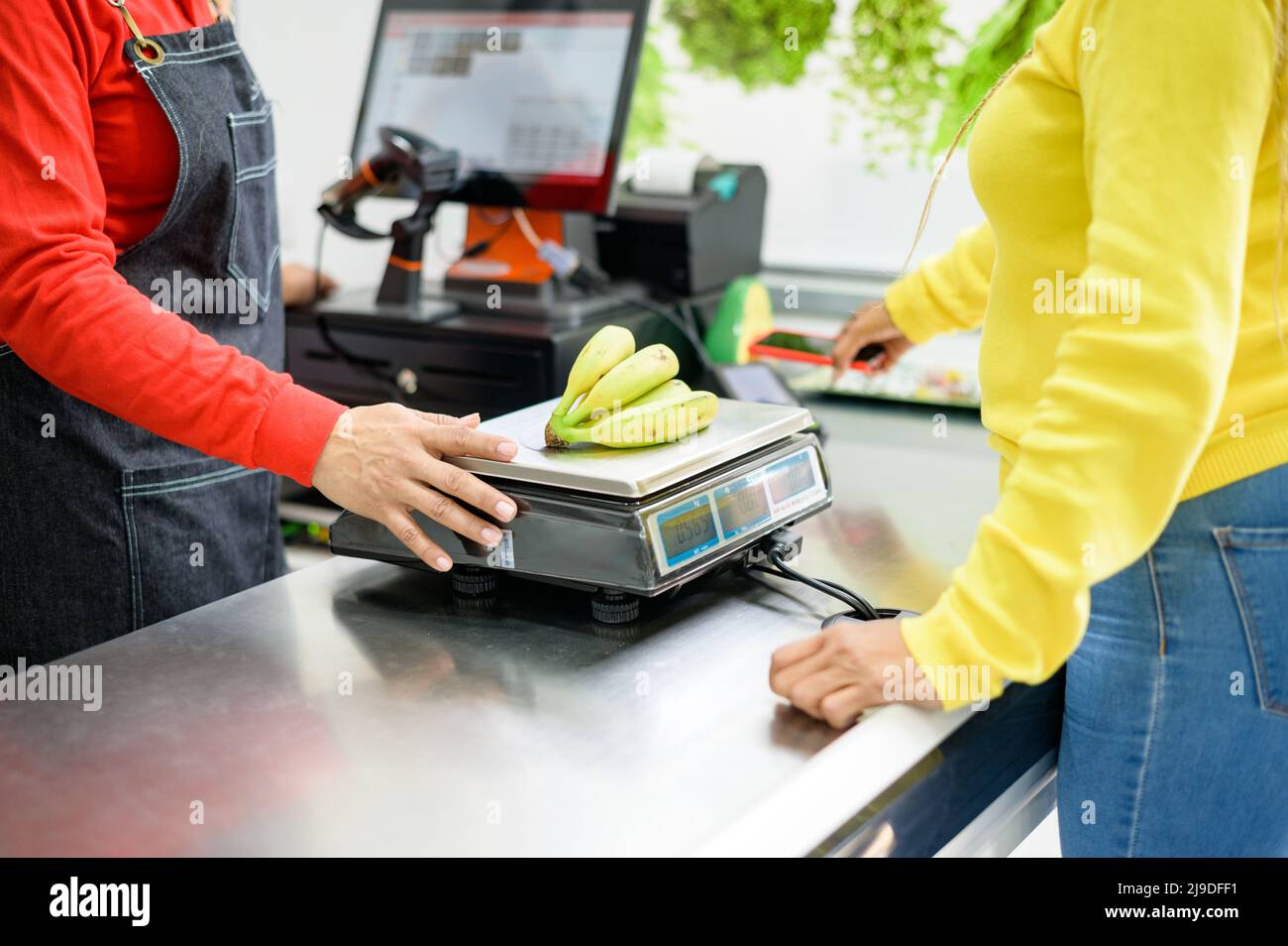 Crop seller weighing bananas for customer Stock Photo - Alamy