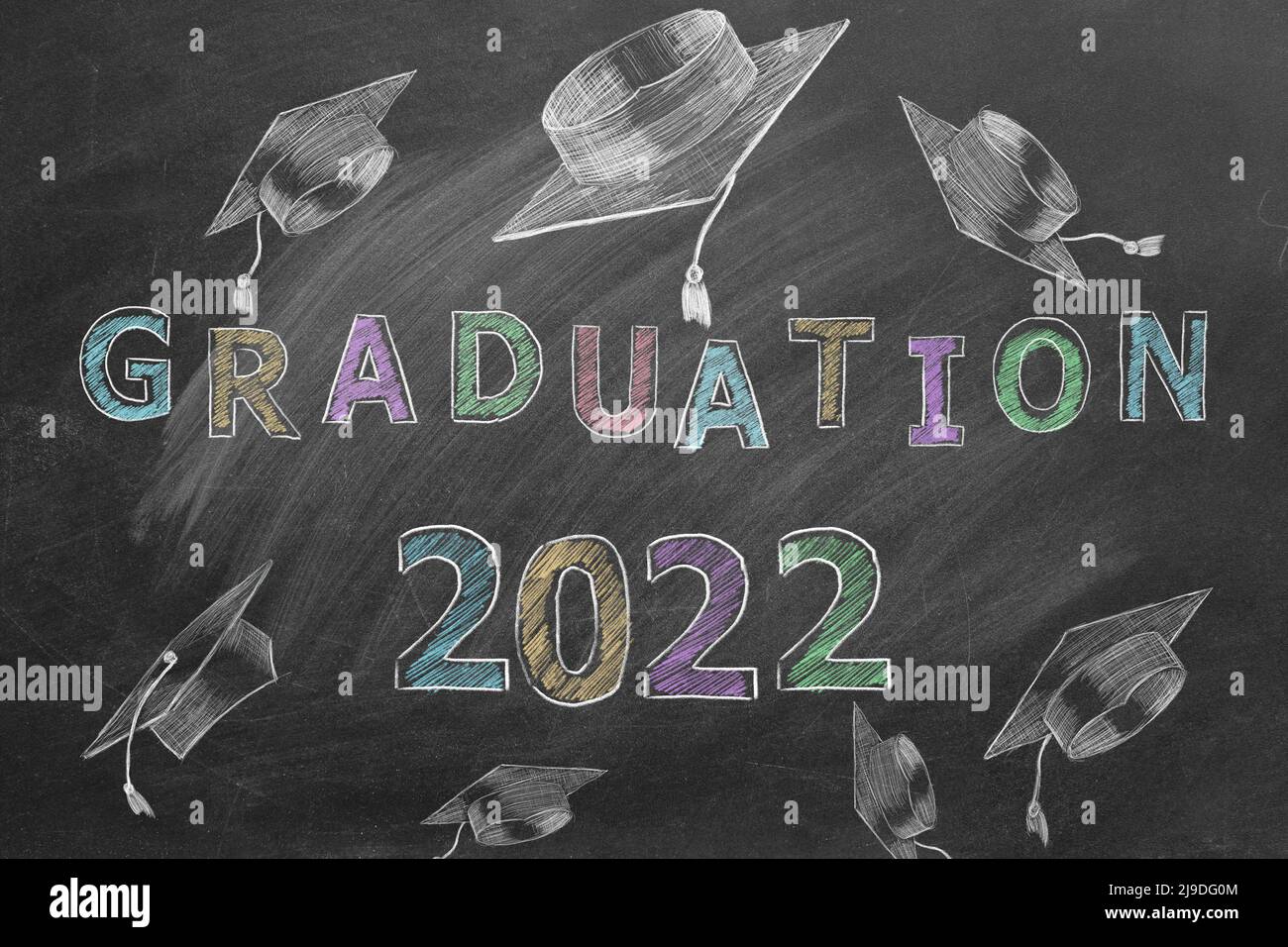 Hand drawn text GRADUATION 2022 and graduation caps on blackboard Stock ...