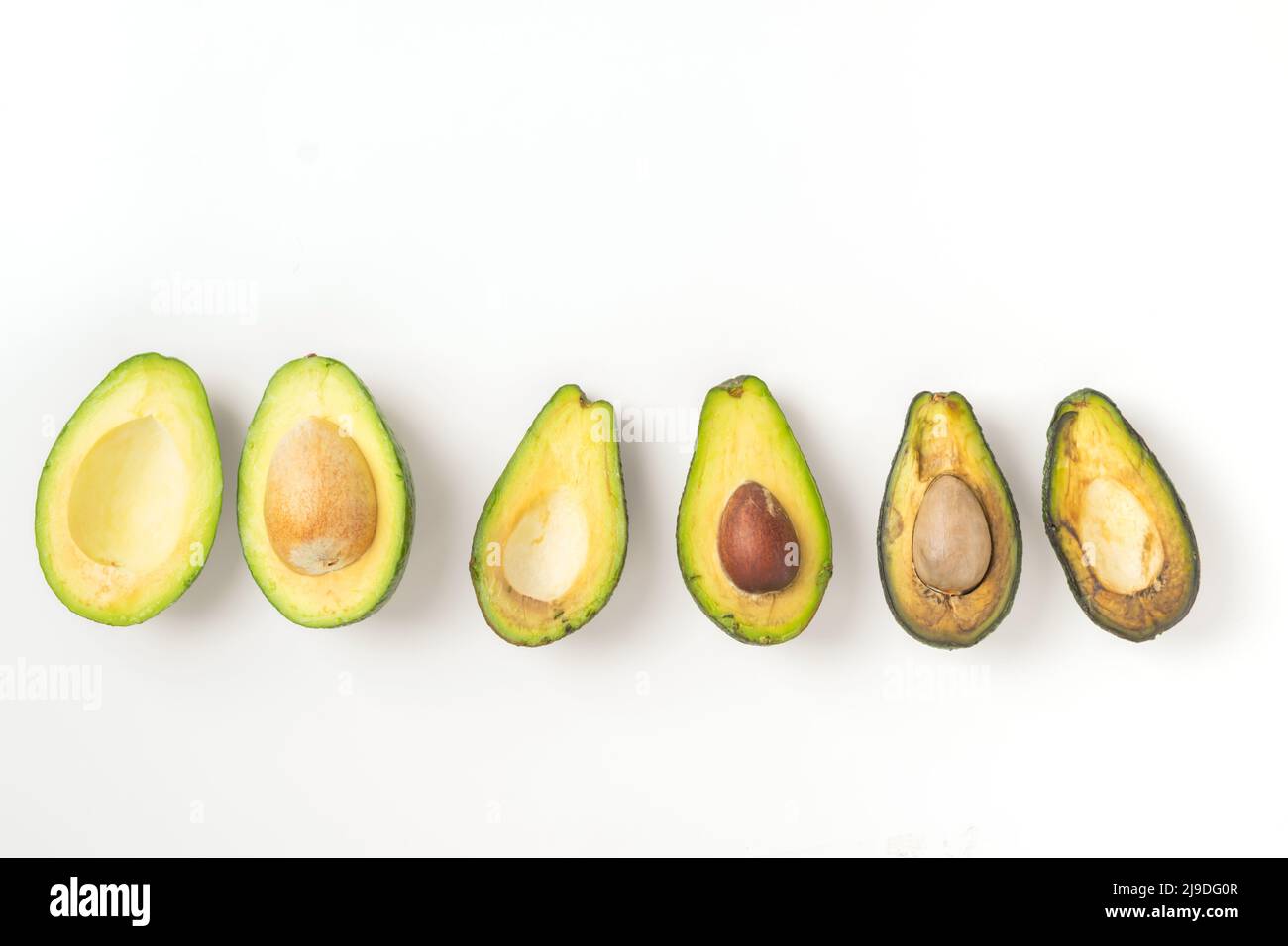 Ripe and spoiled rotten fruit vegetables avocado in a cut, white ...