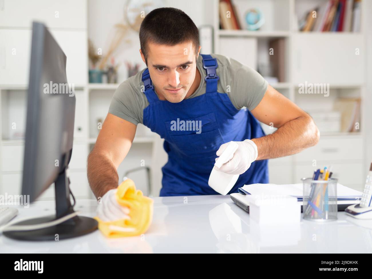 Cleaning worker wiping office desk with detergent Stock Photo - Alamy