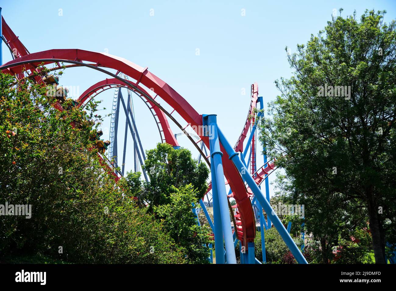 Inverted roller coaster with narrow metal rails, an ideal summer day to ...