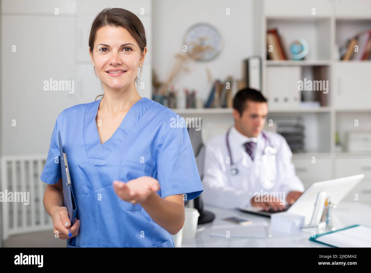 Female doctor making welcome gesture, politely inviting patient in ...