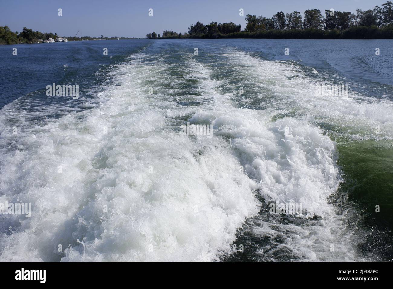 Waves and water stirred by the propellers of a ship's engine as it ...