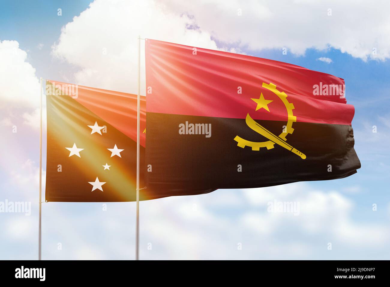 Sunny blue sky and flags of angola and papua new guinea Stock Photo - Alamy