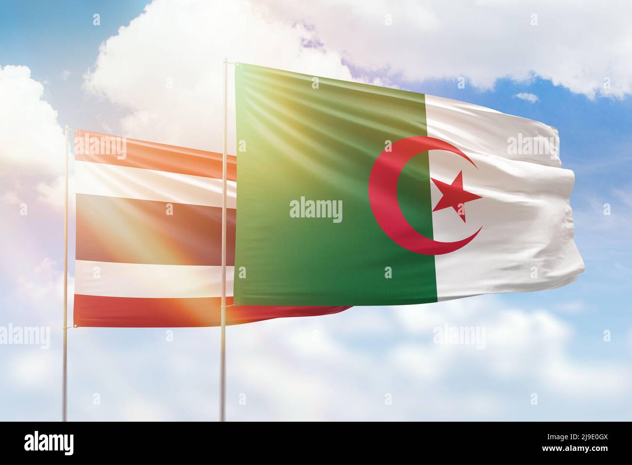 Sunny blue sky and flags of algeria and thailand Stock Photo - Alamy