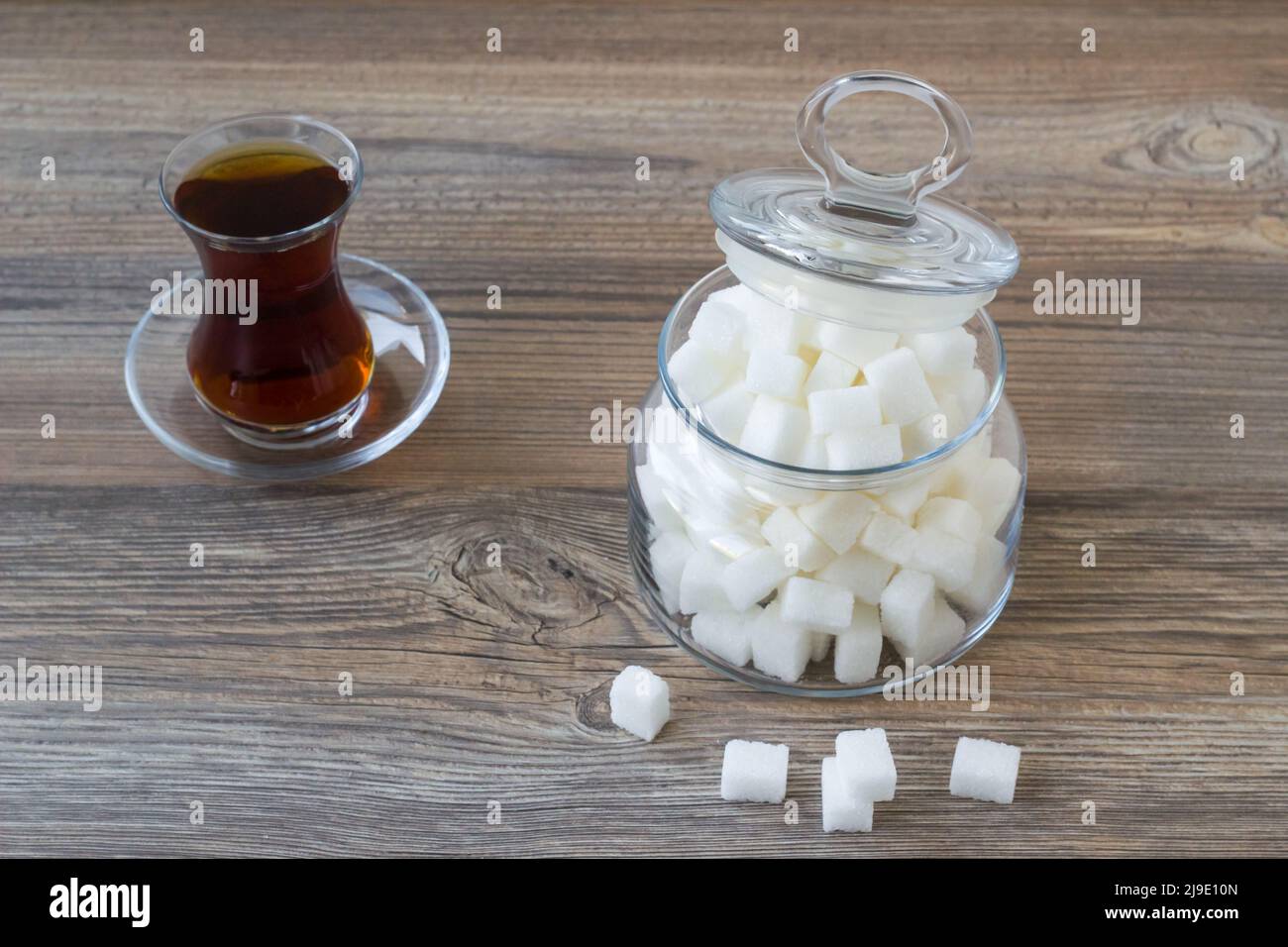 Traditional Turkish Tea with jar full of white sugar cubes on wooden ...