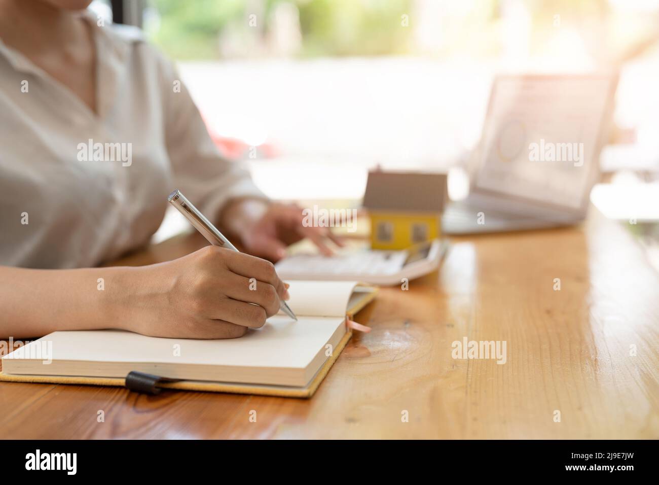 Close up real estate agent working with calculator taking note for ...