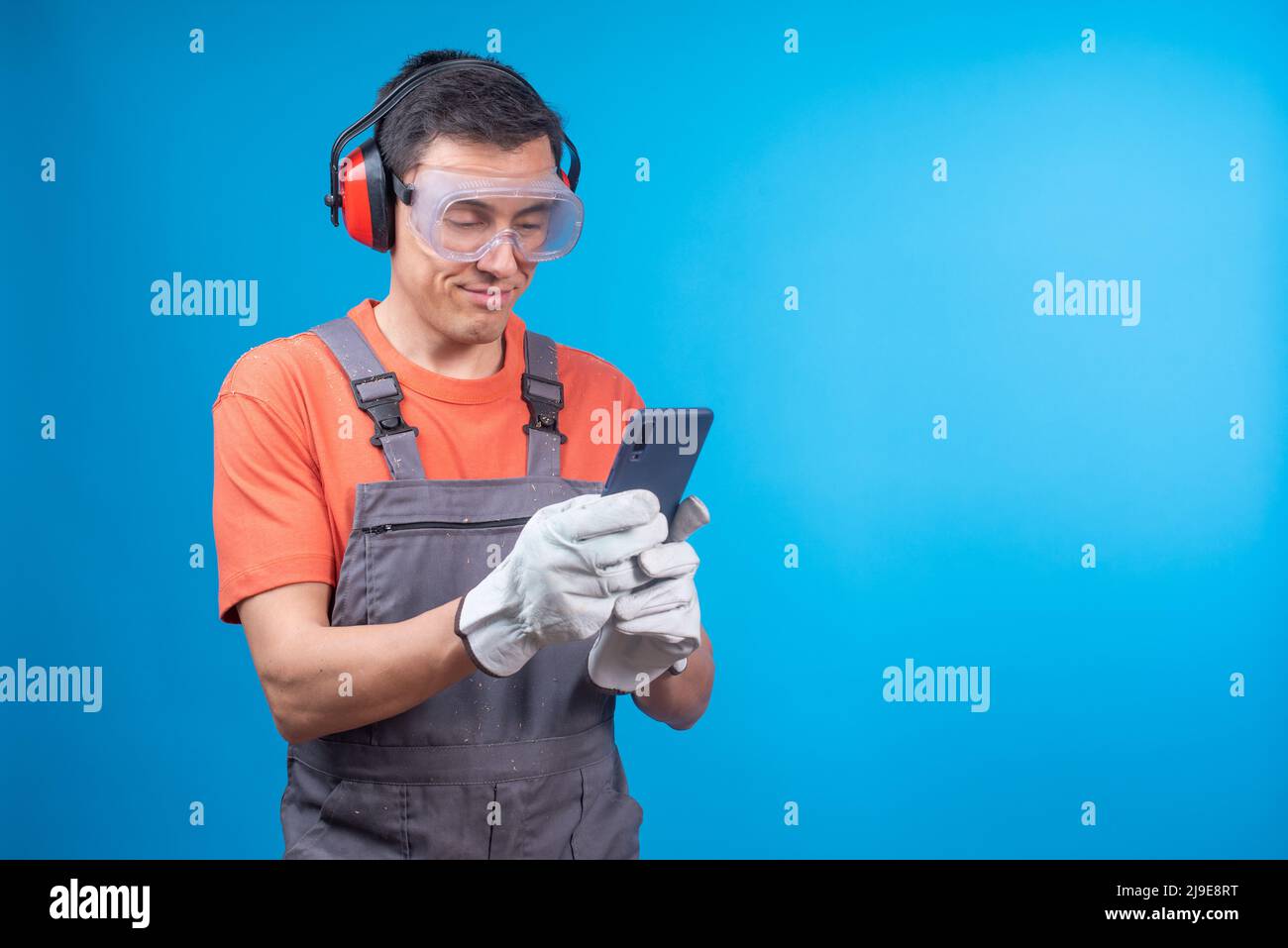 Male carpenter sending text message on smartphone Stock Photo - Alamy