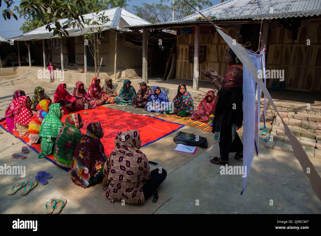 Local NGO workers conducting a courtyard meeting to train rural women ...