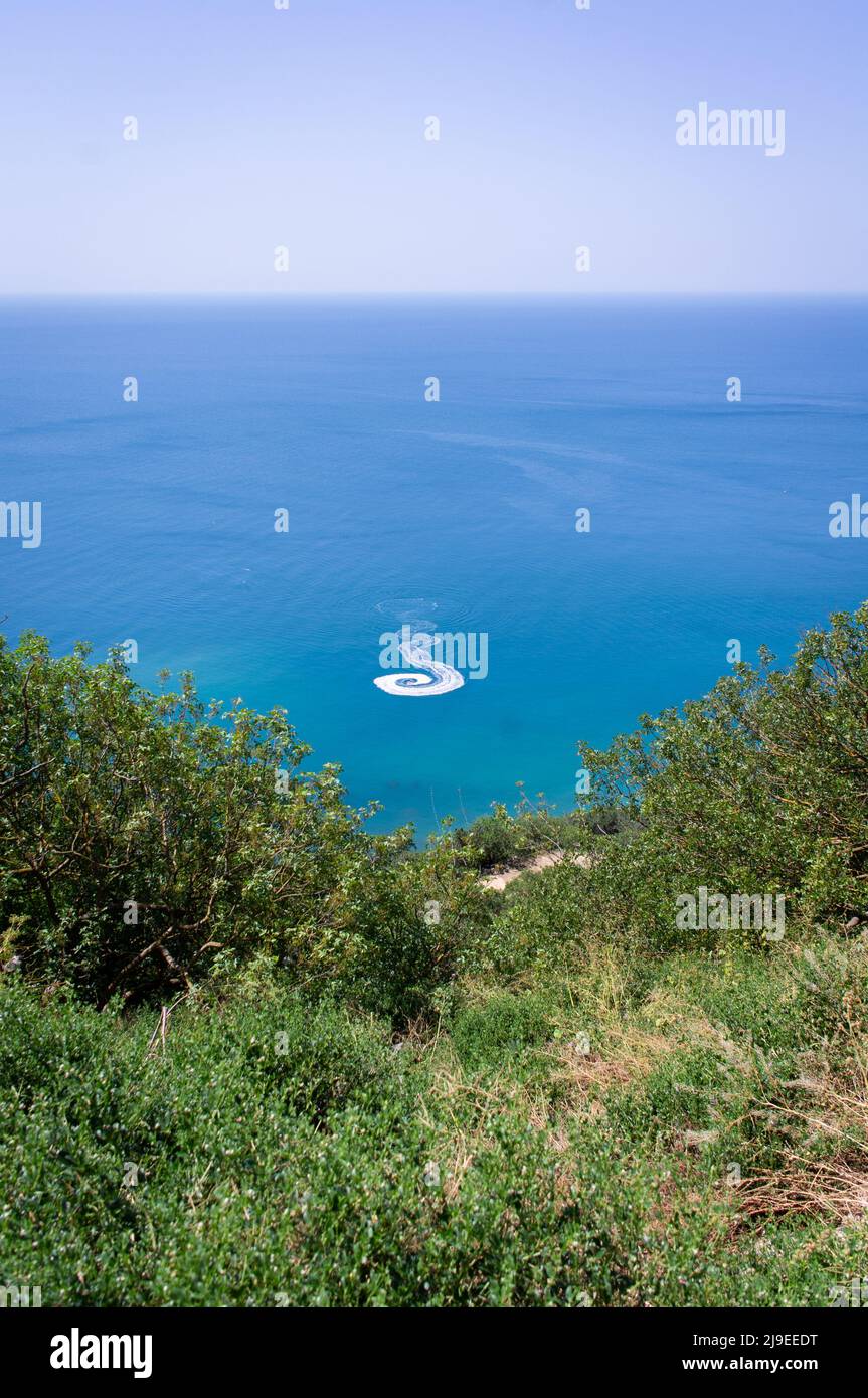 Seascape, rocks and greenery, the southern sea. A ship on the water ...