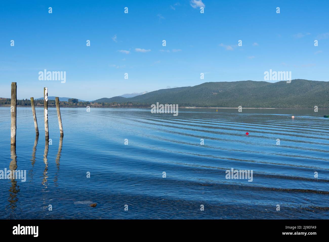 Small ripple on calm blue lake Stock Photo - Alamy