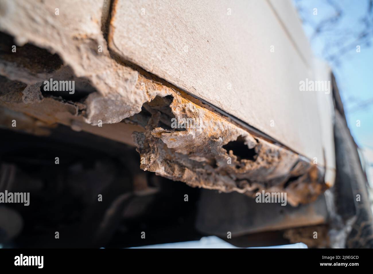 Rusted white car sills close-up. The effect of reagents in winter on an ...