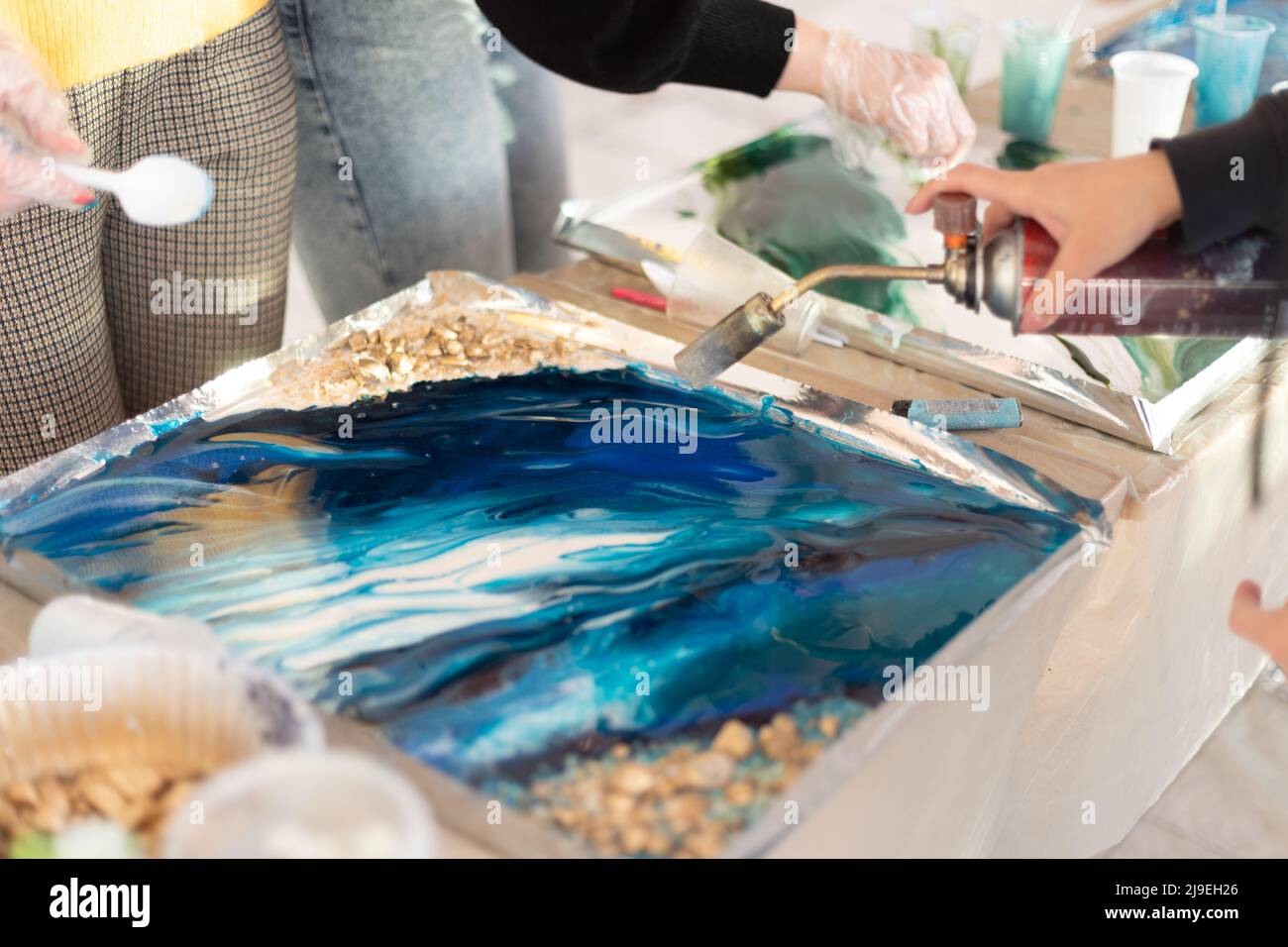 Drying paint in blue color with a hairdryer on the board. Female hand ...