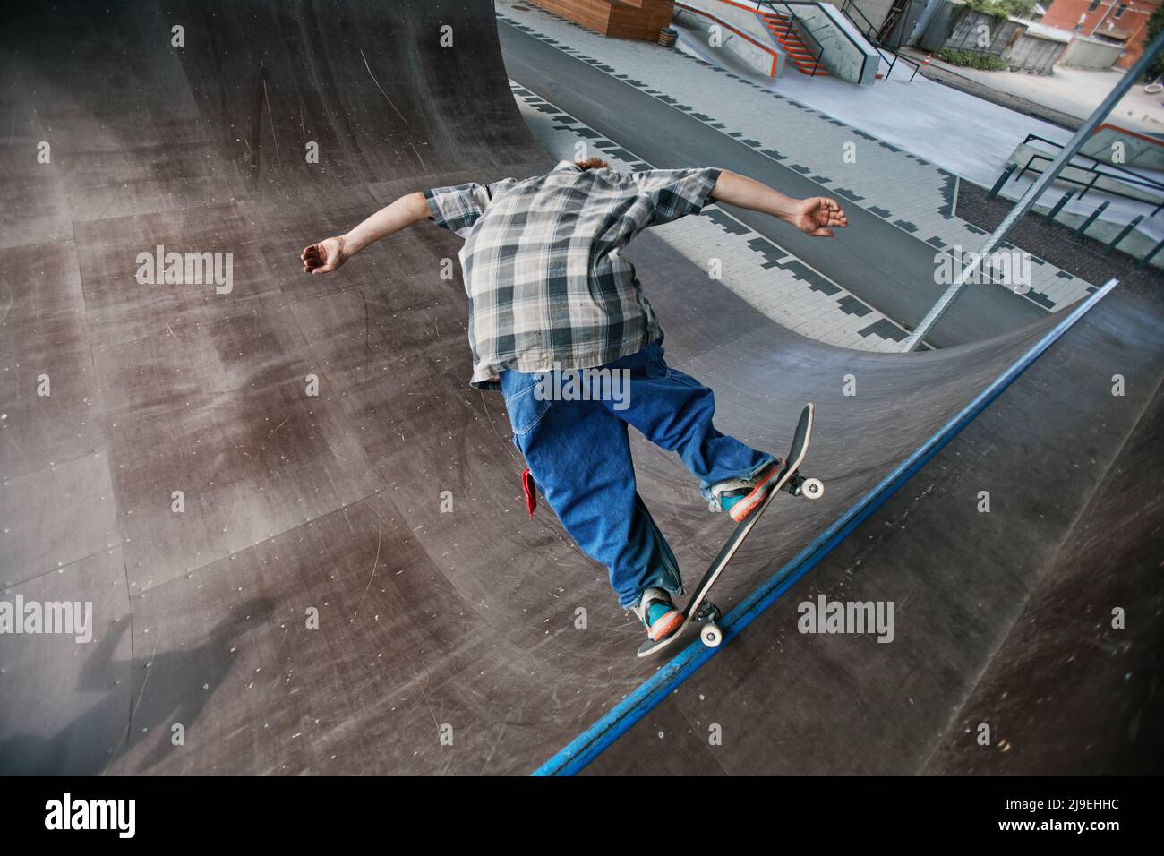 Action shot of teenager riding skateboard on ramp at skating park and ...