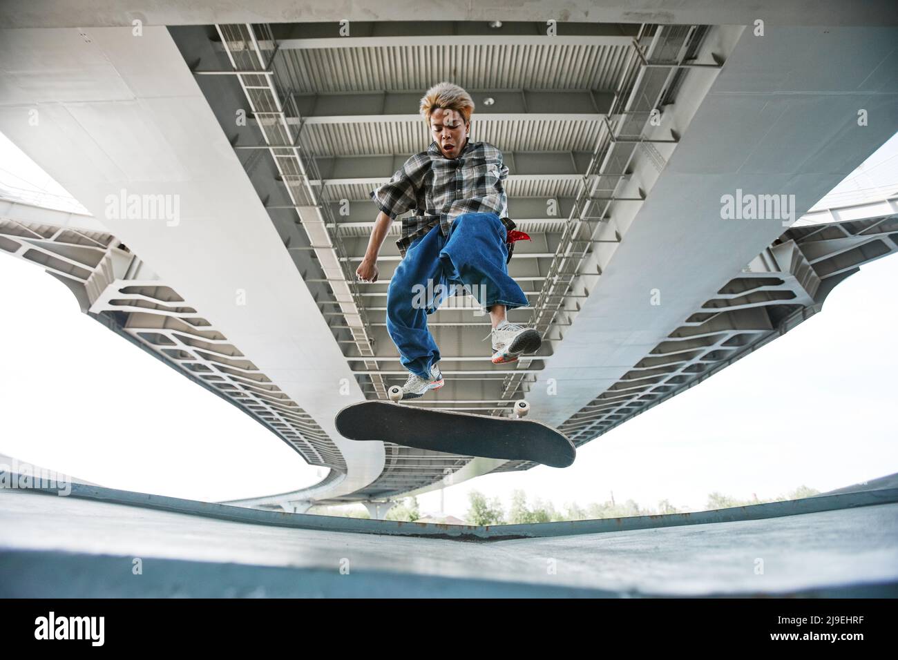 Graphic action shot of young teenager riding skateboard in urban area ...