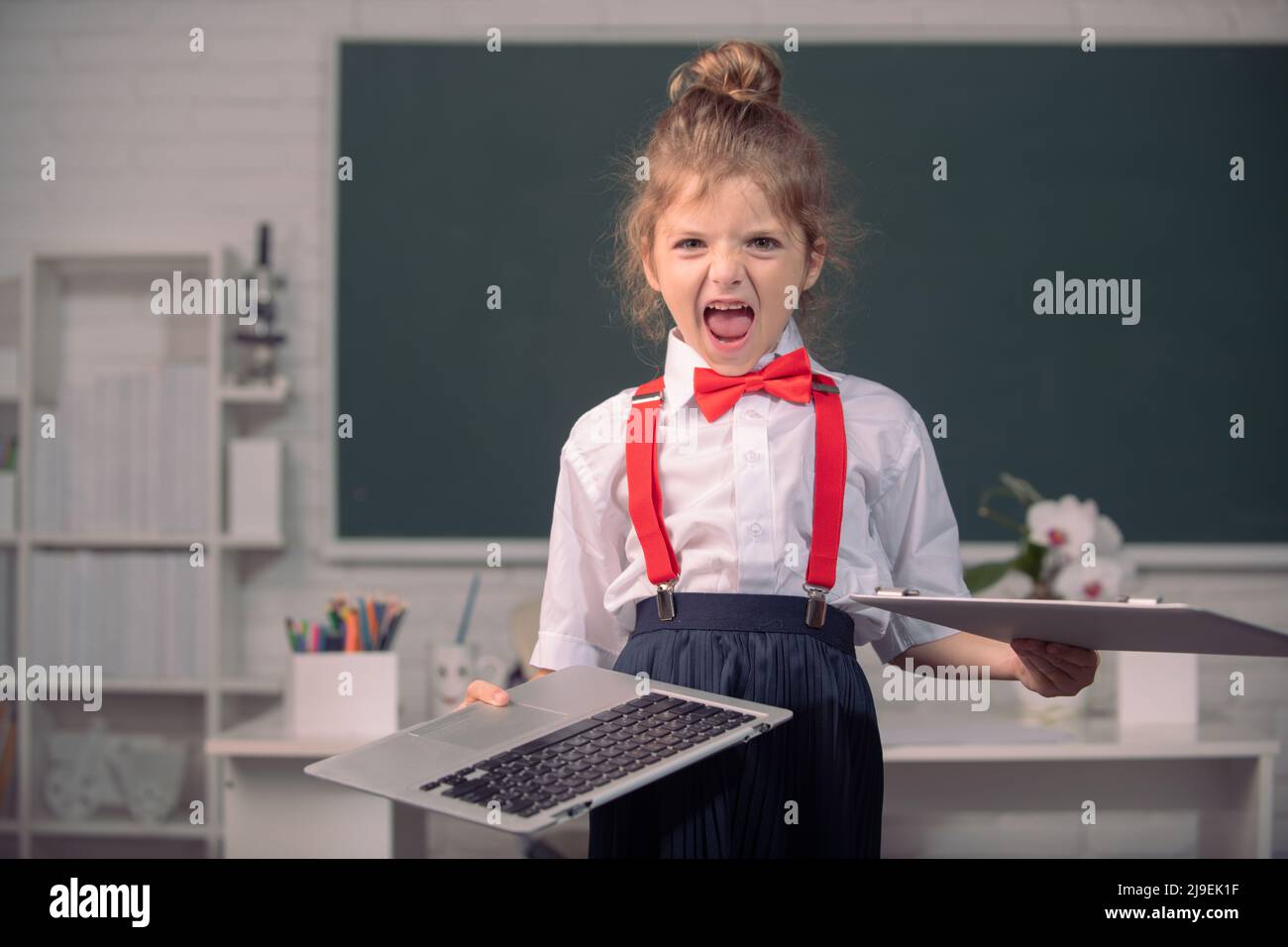 Angry kid broken online laptop at school. Bad girl student in ...