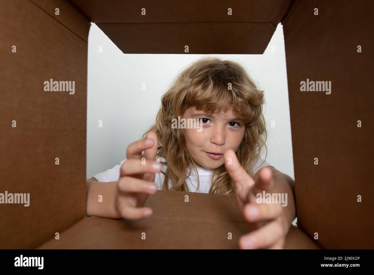 The surprised child age 8 year unpacking, opening carton box and ...