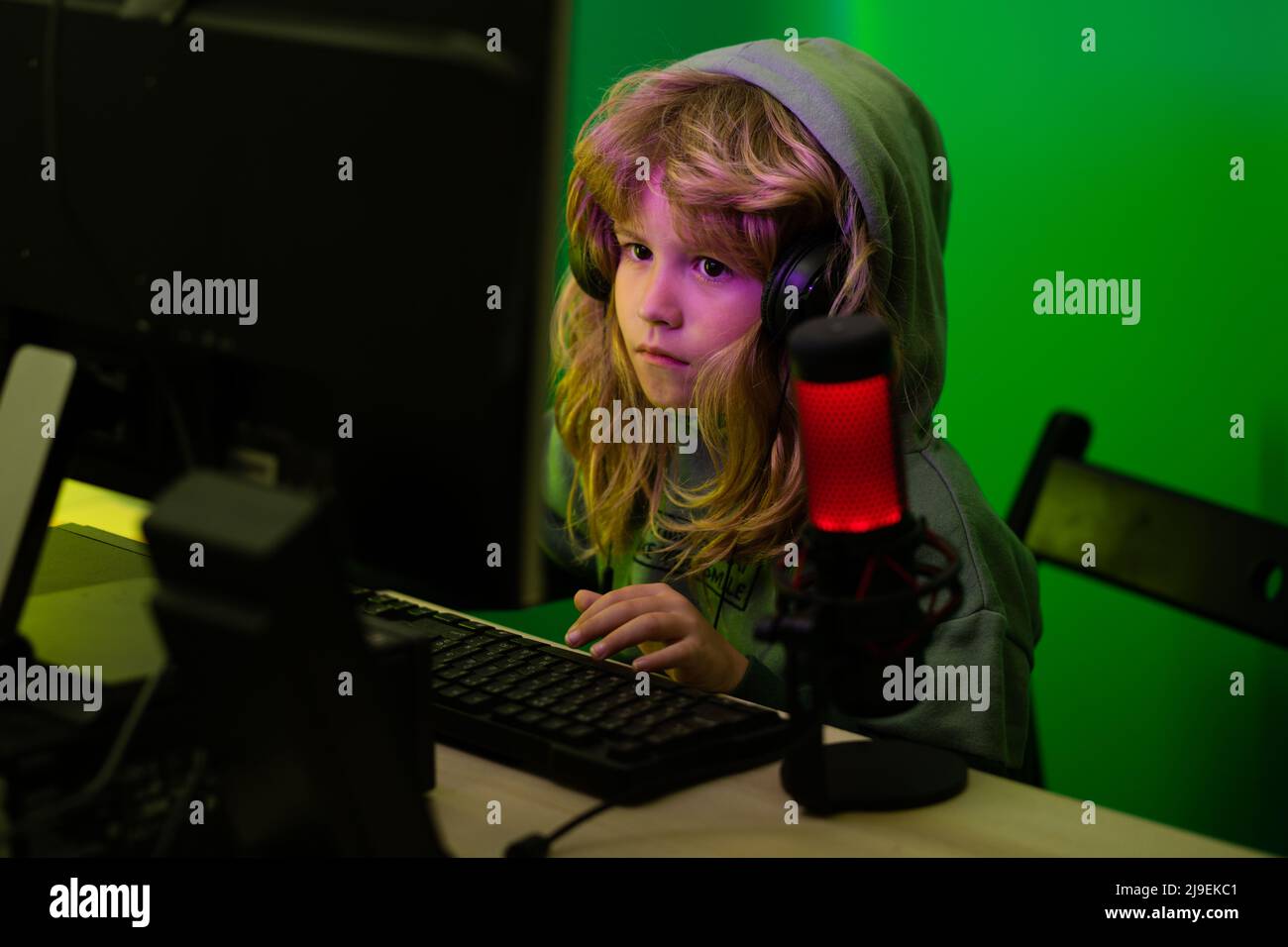 Little child gamer play computer game on desktop. Gaming stream and ...