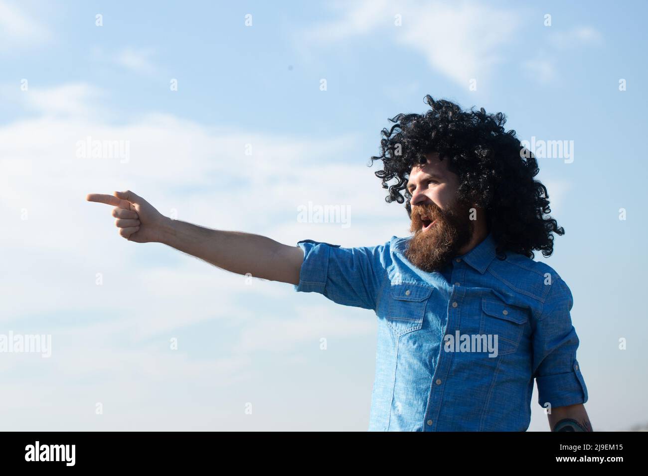 Crazy funny bearded man with black wig pointing finger on sky ...