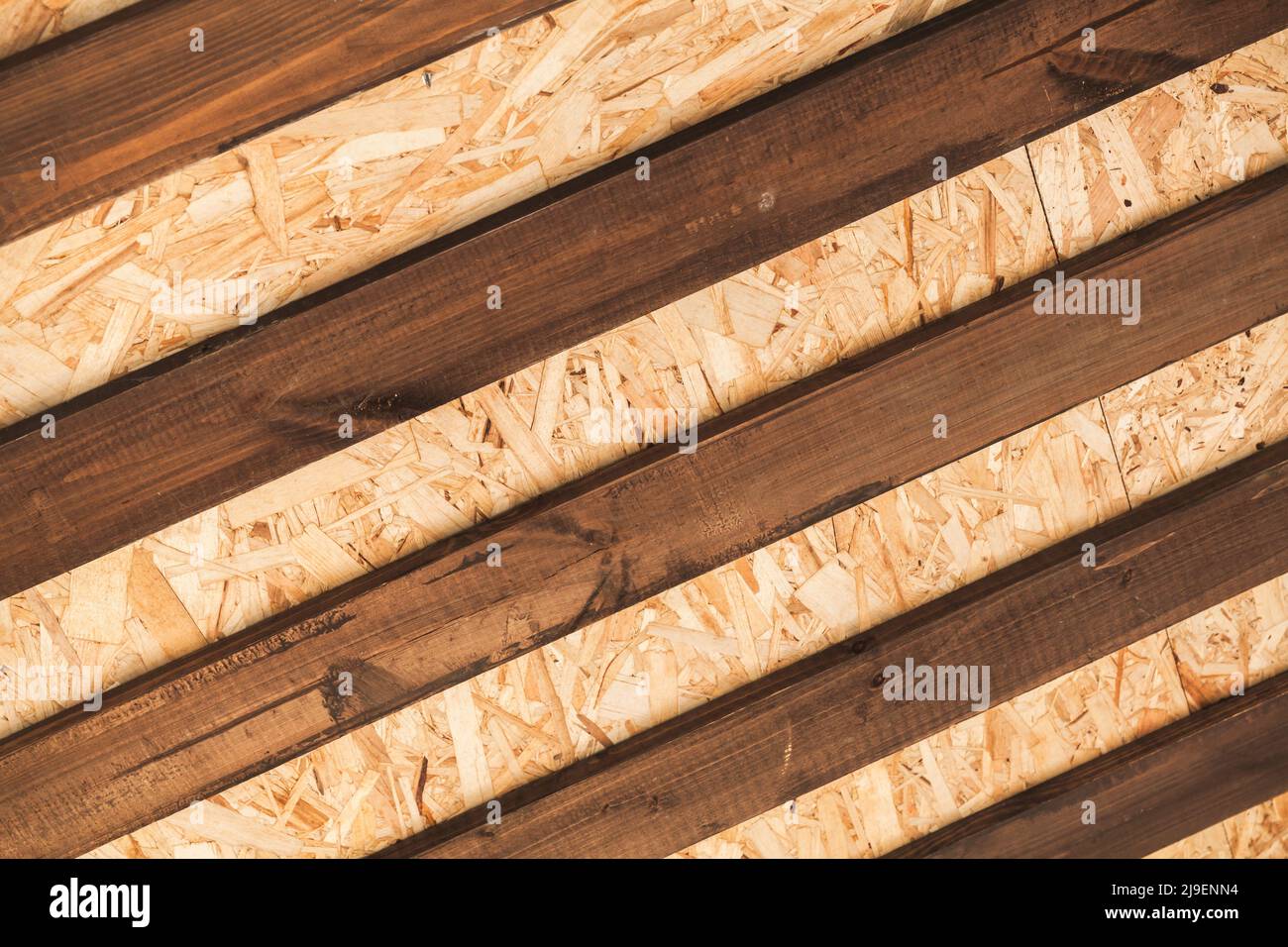 Internal details of wooden roof, framework of brown boards and layer of ...