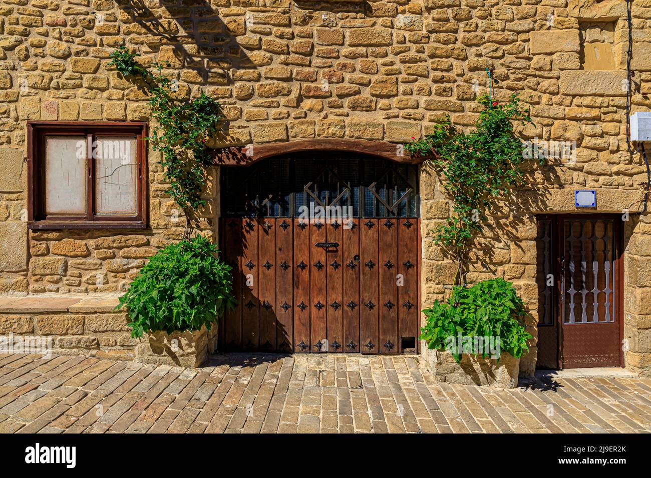 Old stone house facade with a wooden gate on the streets in a ...