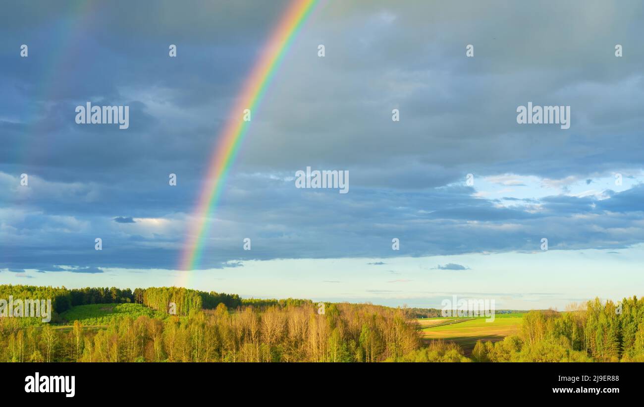 A real double rainbow in a cloudy sky after heavy rain. A rare natural ...
