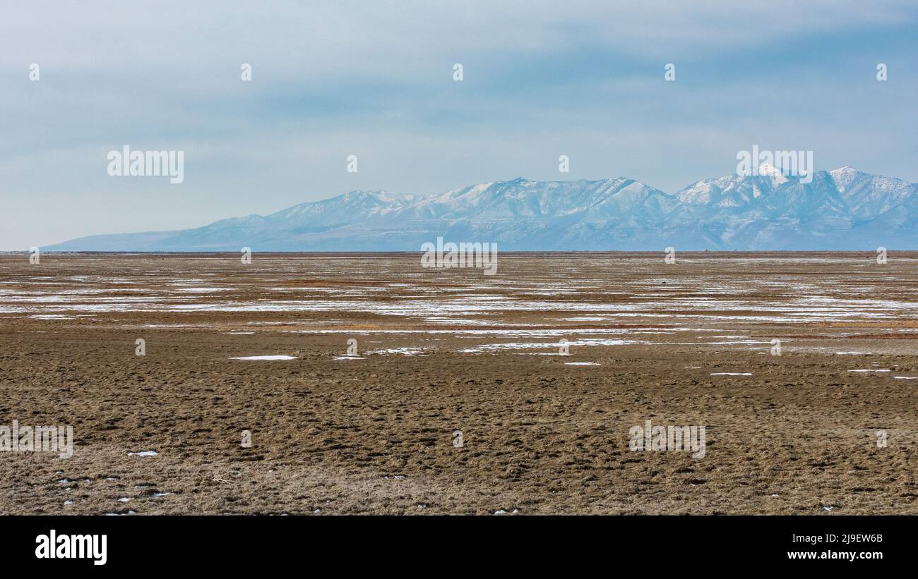 Snow capped mountains stand tall through haze in Bear River Migratory ...
