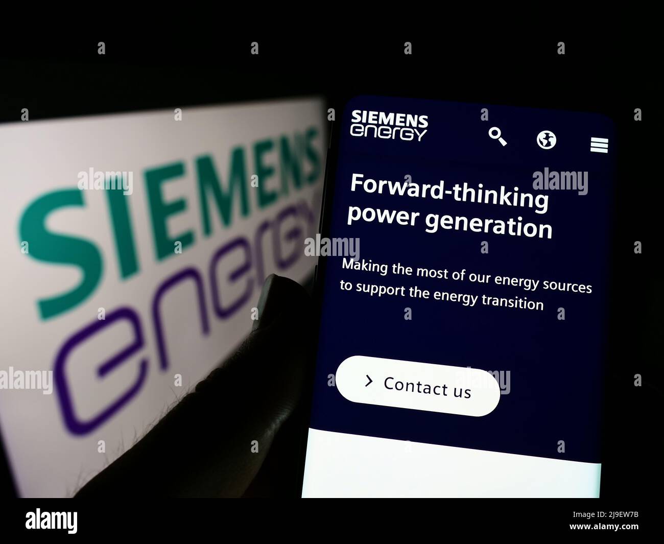 Person holding smartphone with webpage of German technology company ...