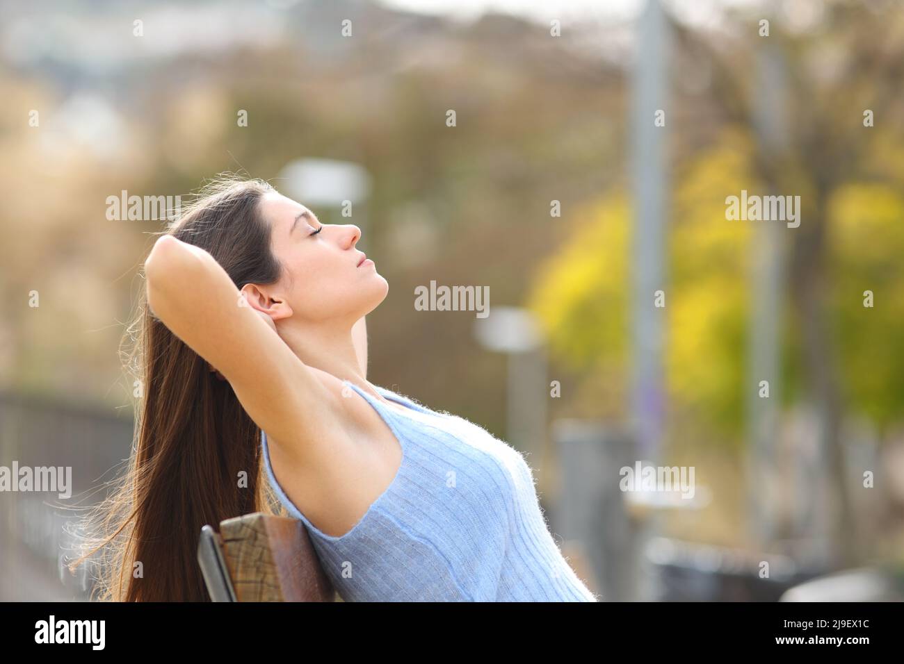 Side view portrait of a relaxed teen resting sitting on bench in a park ...