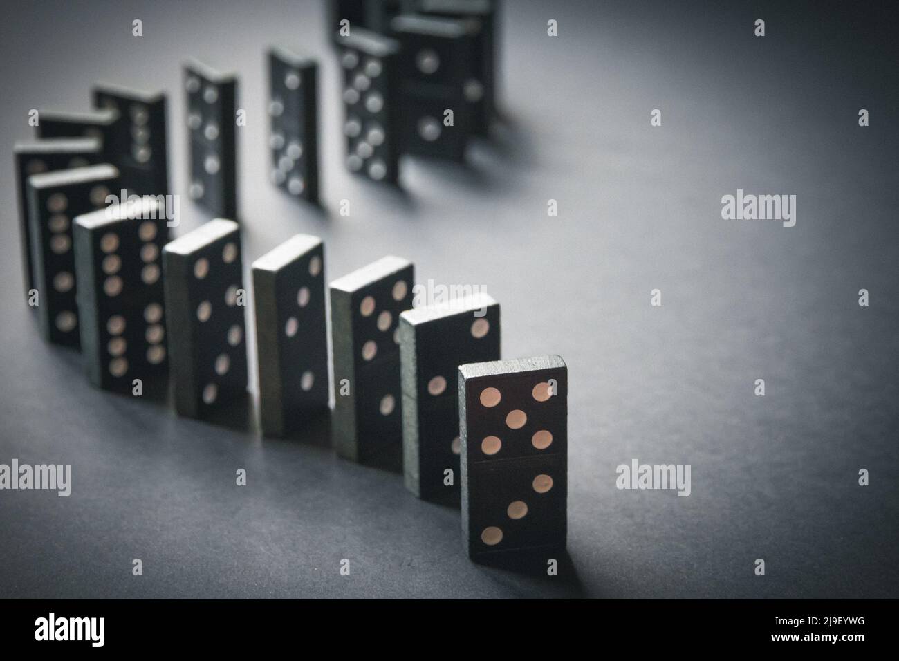 Black dominoes chain on a table background. Domino effect concept Stock ...