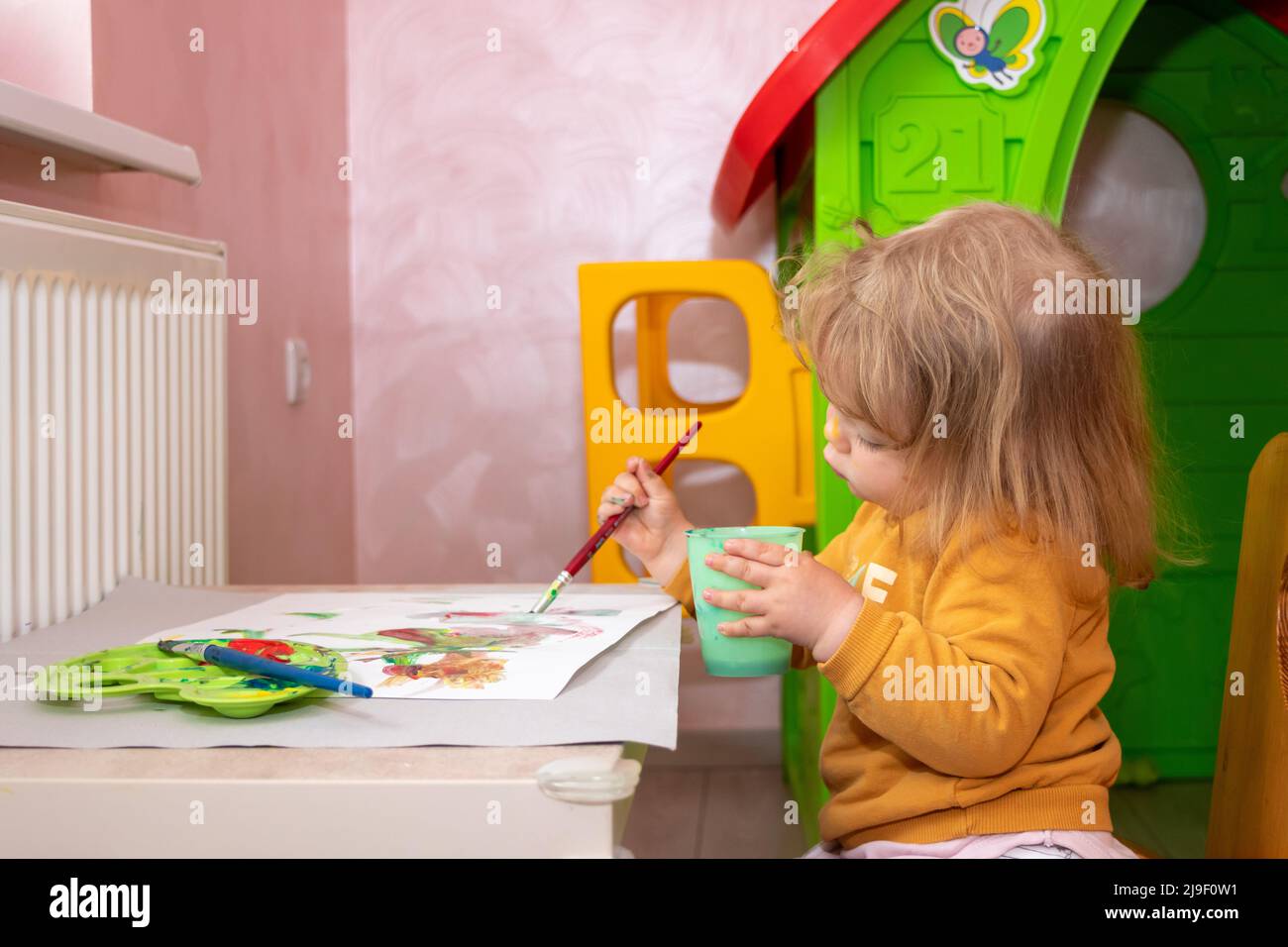 Baby girl drawing with colorful paints at home. Children development ...