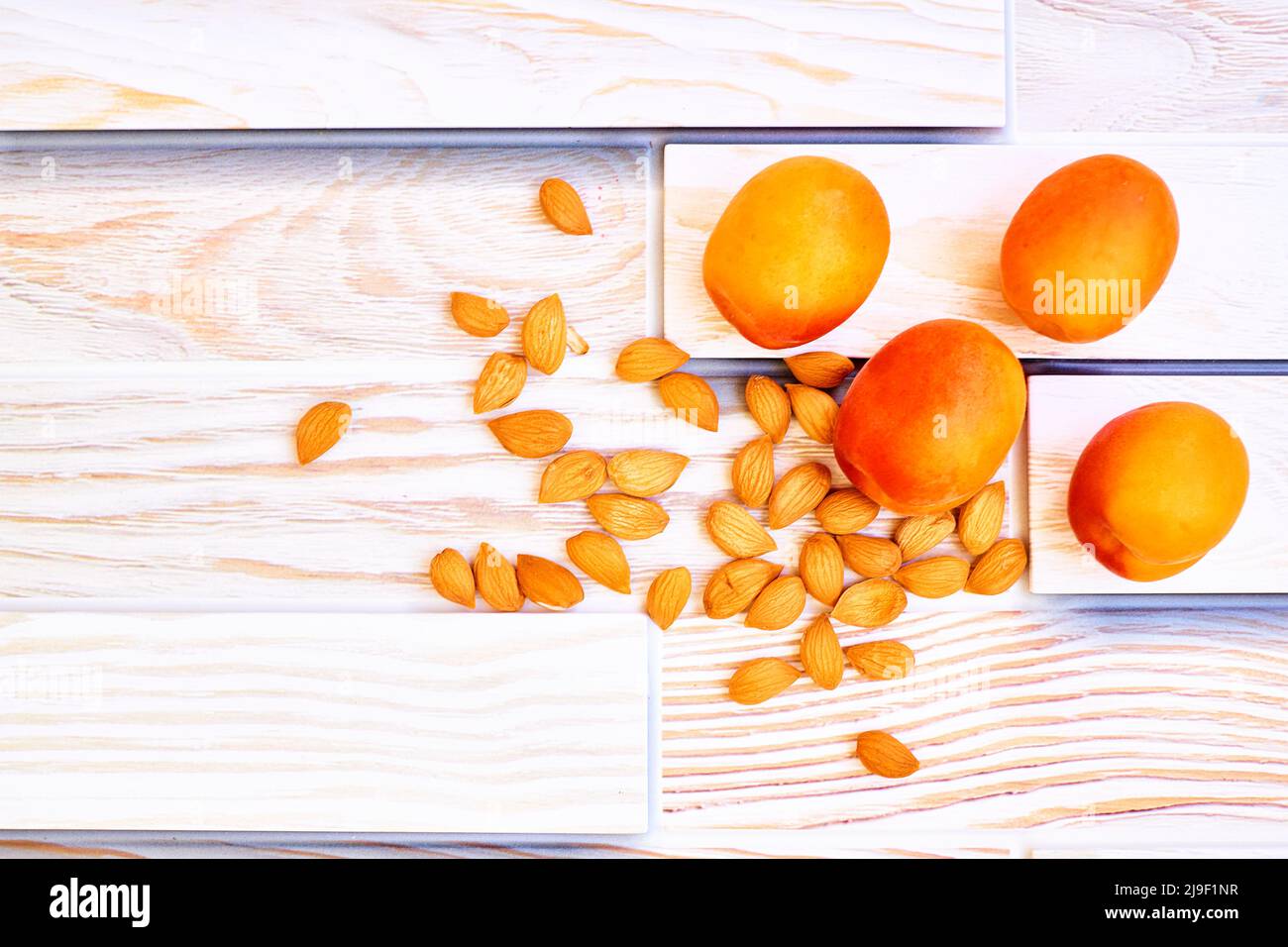 Fresh ripe apricot fruits with kernels isolated on wood background ...