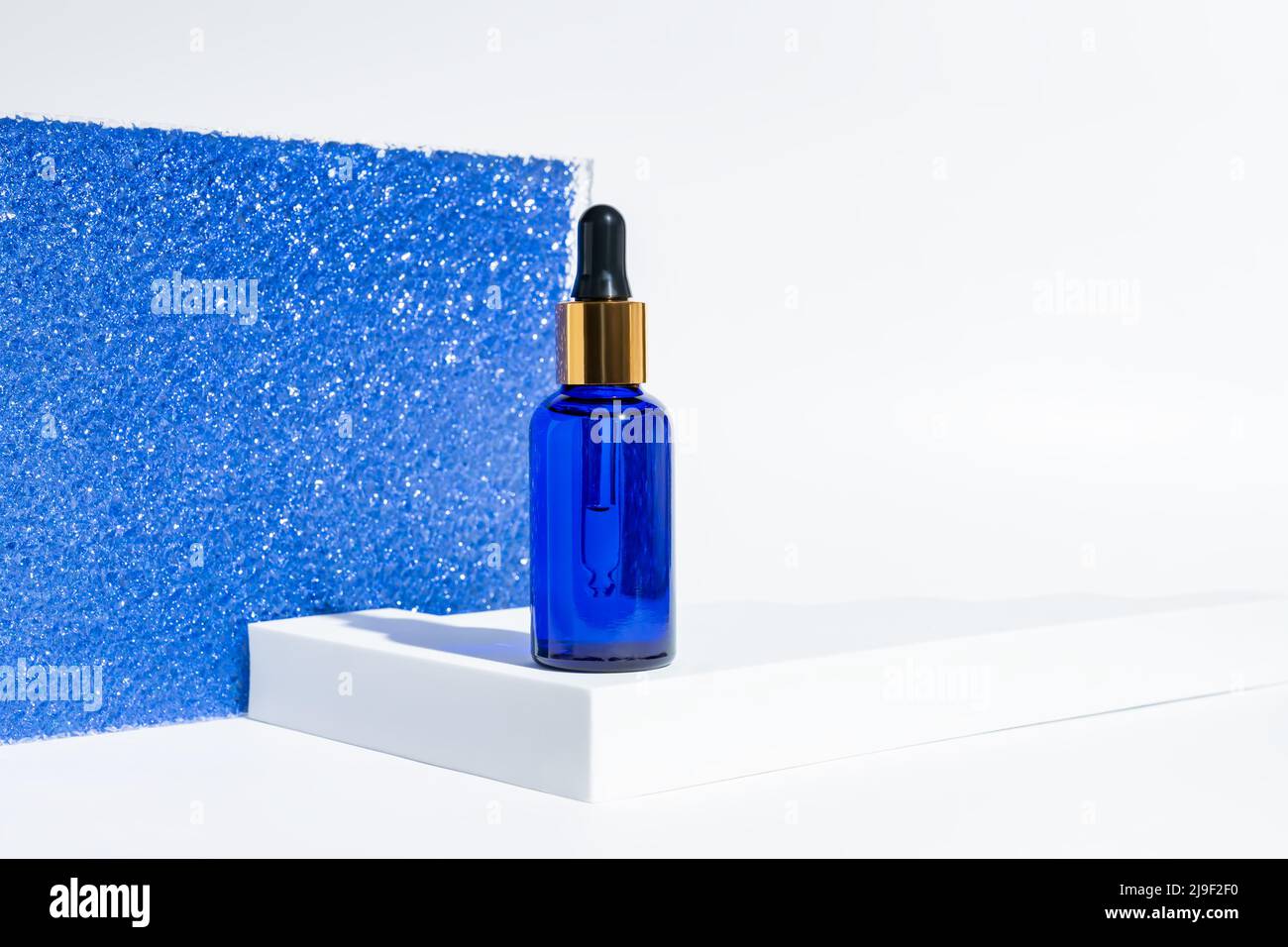 blue glass bottle with beauty serum, hyaluronic acid, collagen and ...