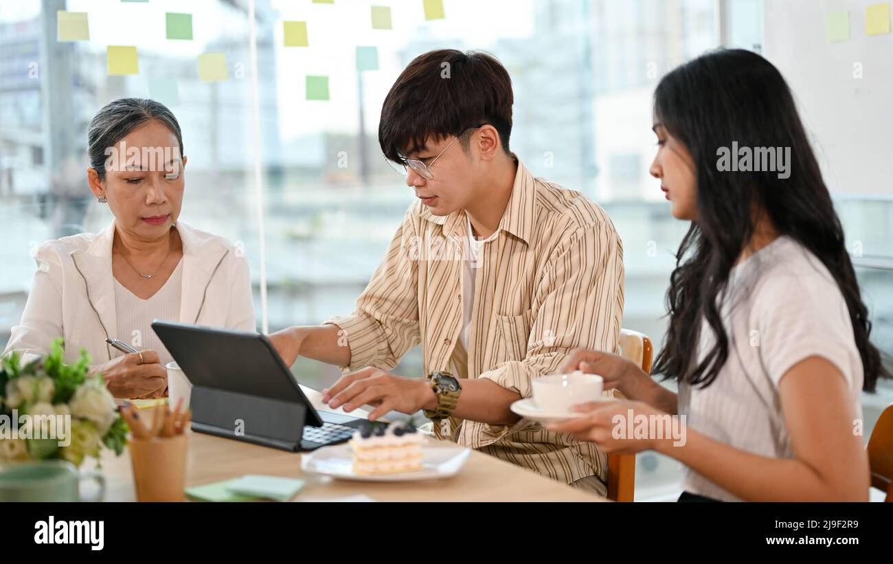 Smart Asian young male software engineer working with senior female ...