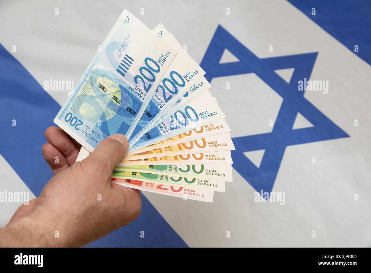 New Israeli shekels banknotes with the new 200 nis. Men hold shekels on ...
