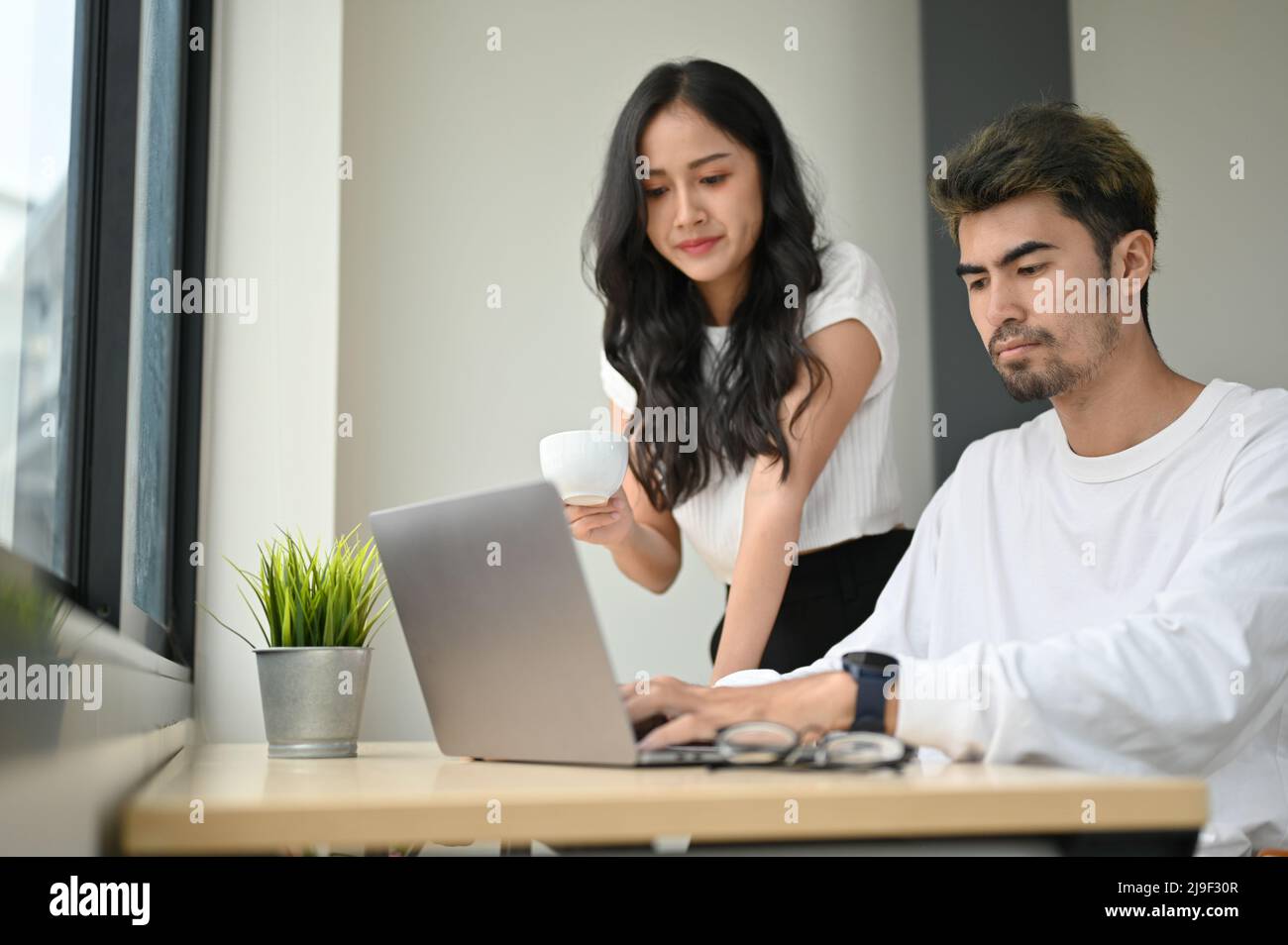 Two of intelligent Asian millennial male and female business worker ...