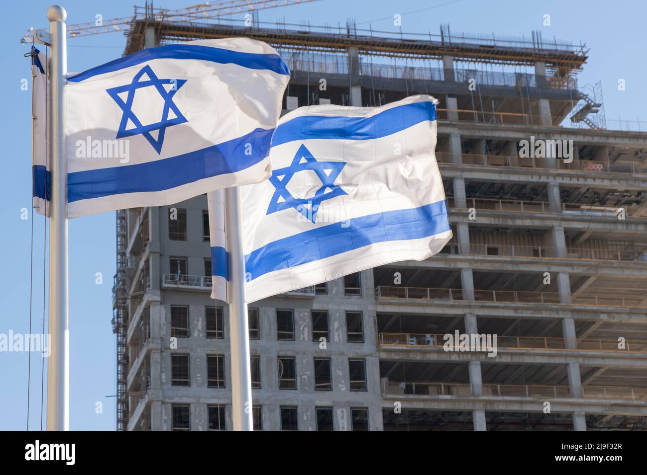 National Israeli flag in the background of Construction site. The ...