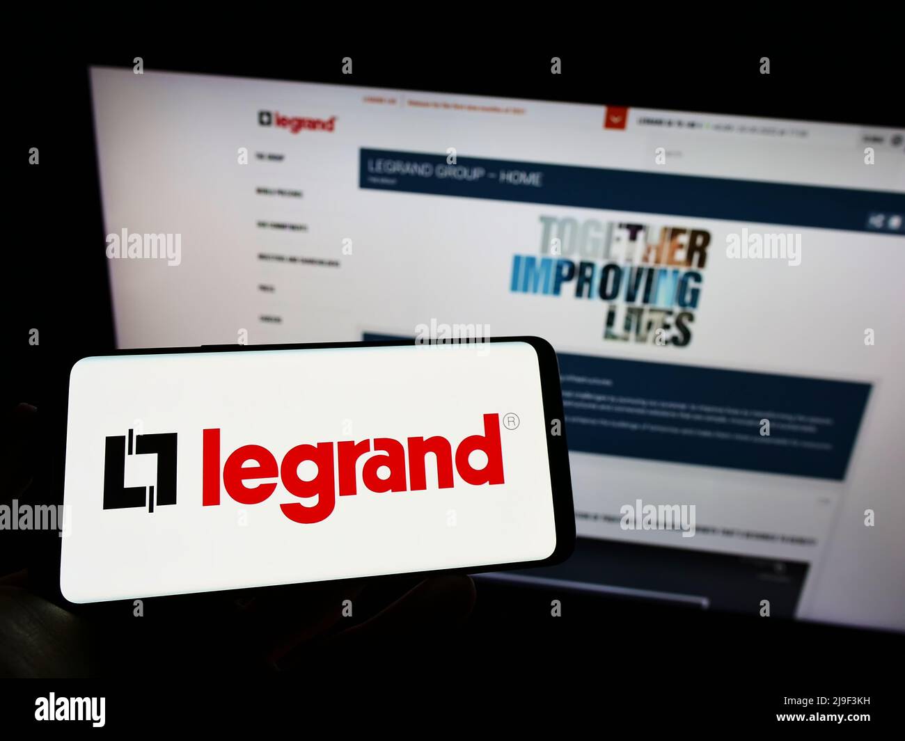 Person holding cellphone with logo of French electronics company ...