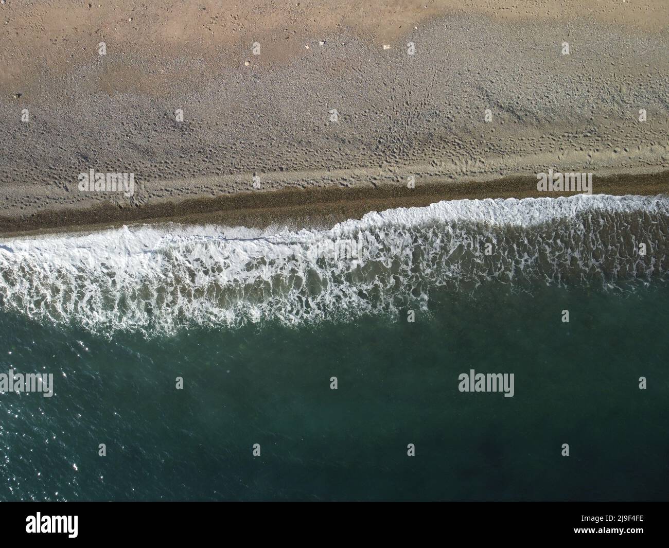 Aerial view from above on calm azure sea and volcanic rocky shores ...