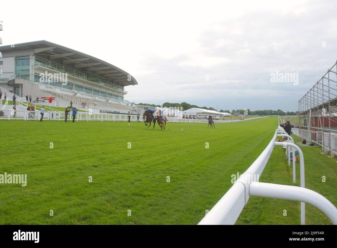 Horses running past the epsom grandstand hi-res stock photography and ...