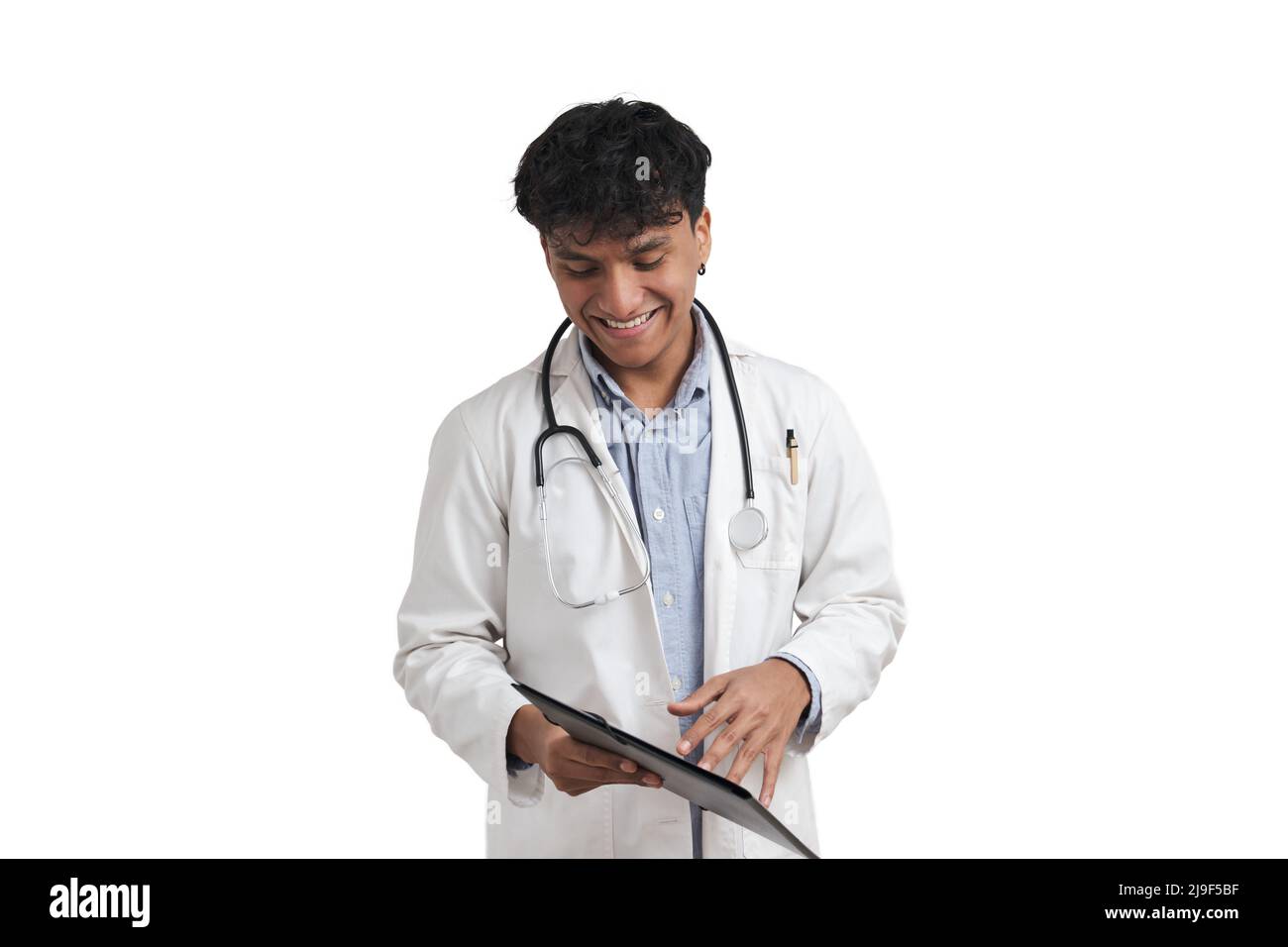 Young peruvian male doctor smiling and looking timidly down, isolated ...