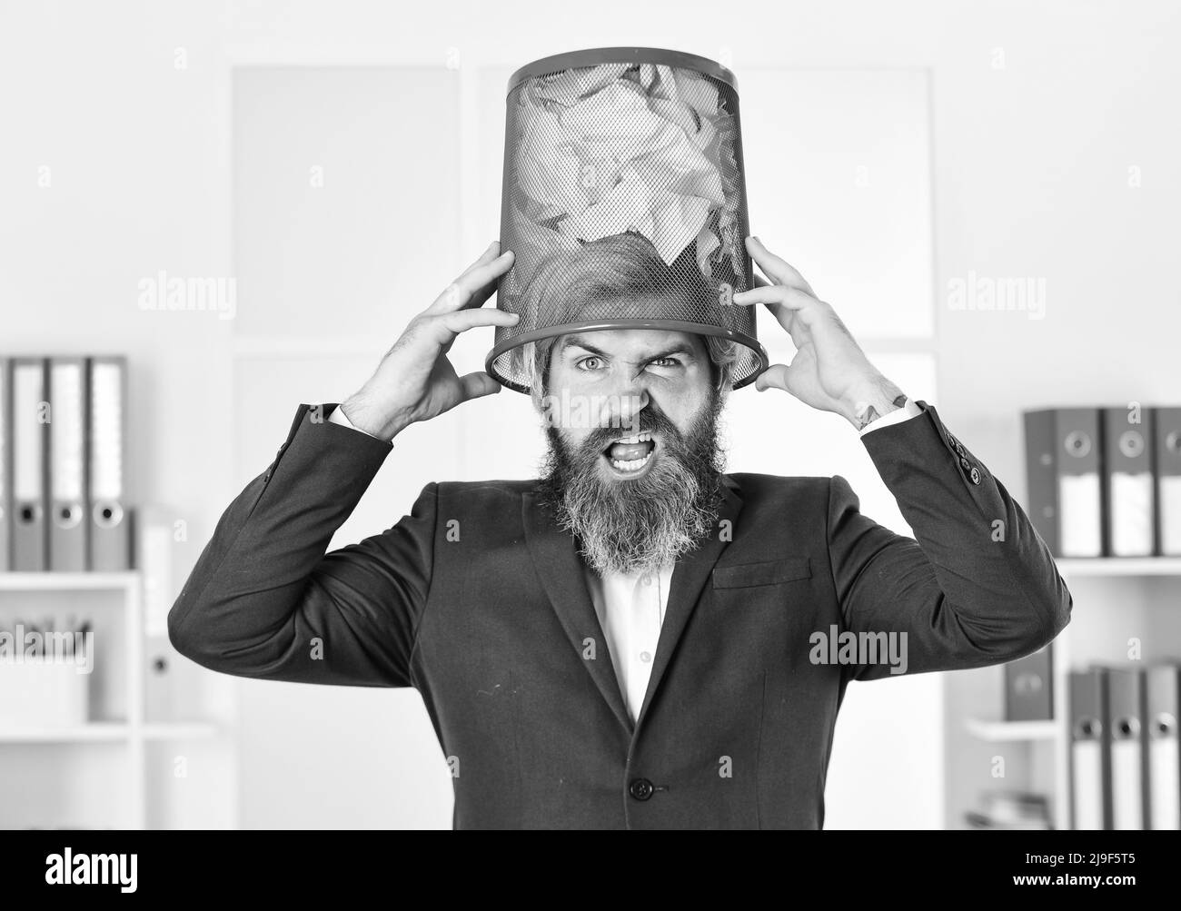 very hard working. crumpled paper in wastepaper basket. man read piece ...