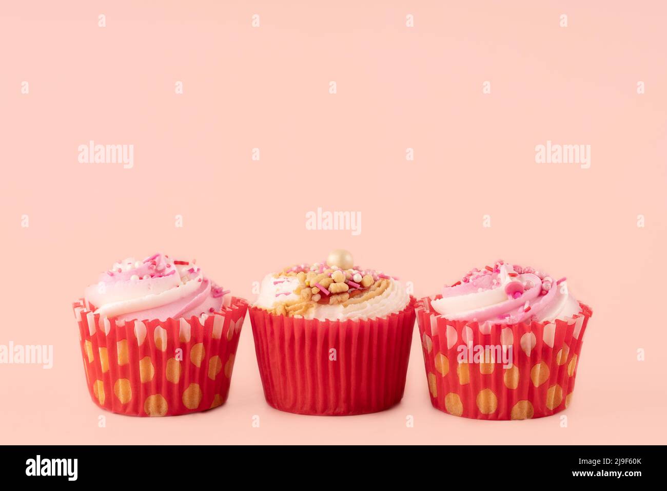 three berry muffins in red wrappers on a pink background high-quality ...