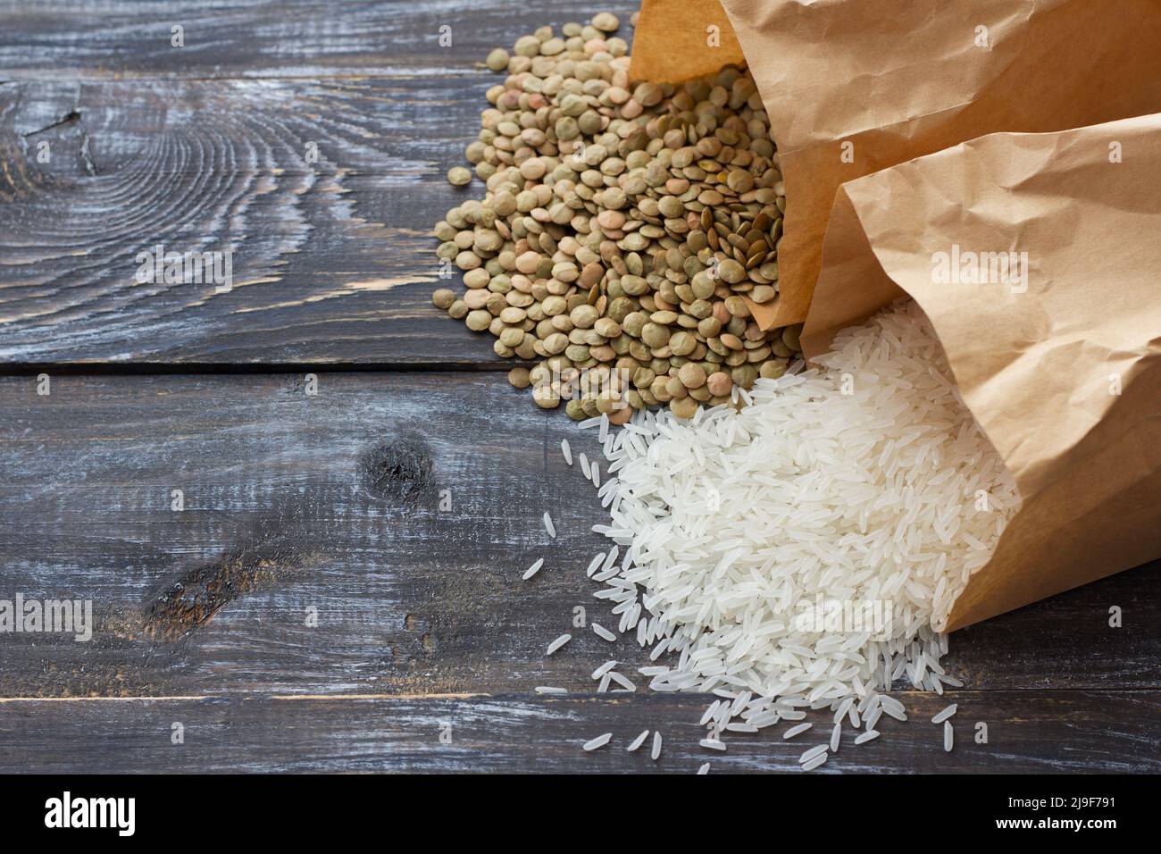 White rice basmati and green lentils in craft bags on a wooden ...