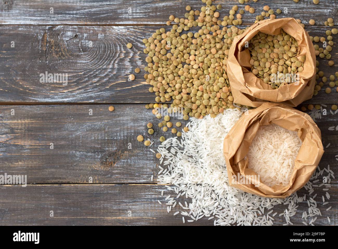 White rice basmati and green lentils in craft bags on a wooden ...