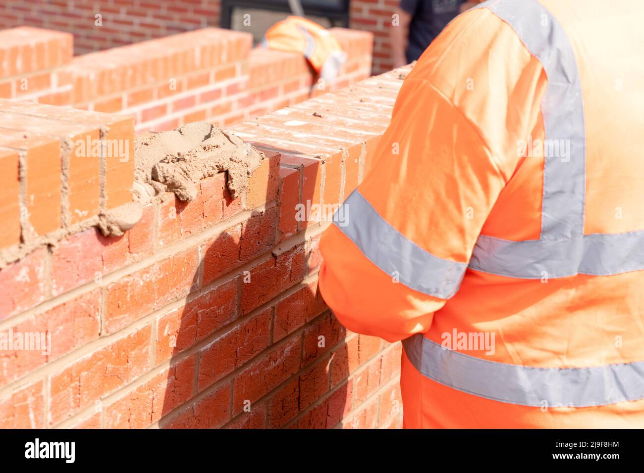 Bricklayer laying bricks on mortar on new residential house ...